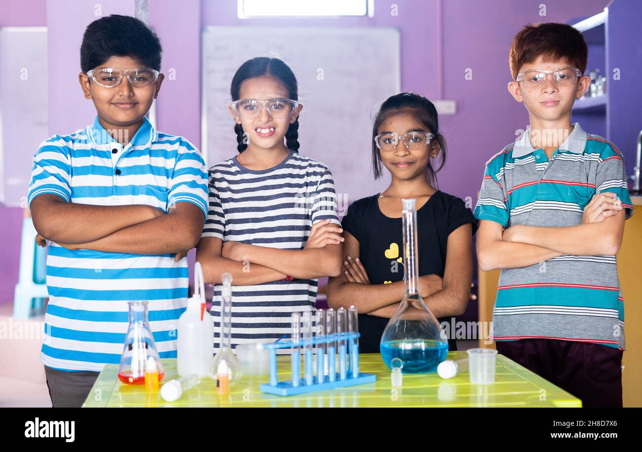 Happy confident school children at science lab in front of experiment ...