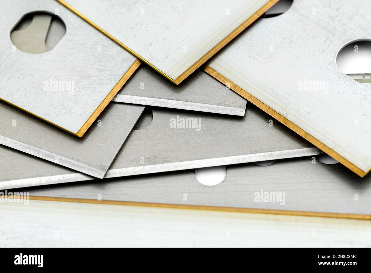 Background made from a macro photo of pile of razor blades with yellow ...