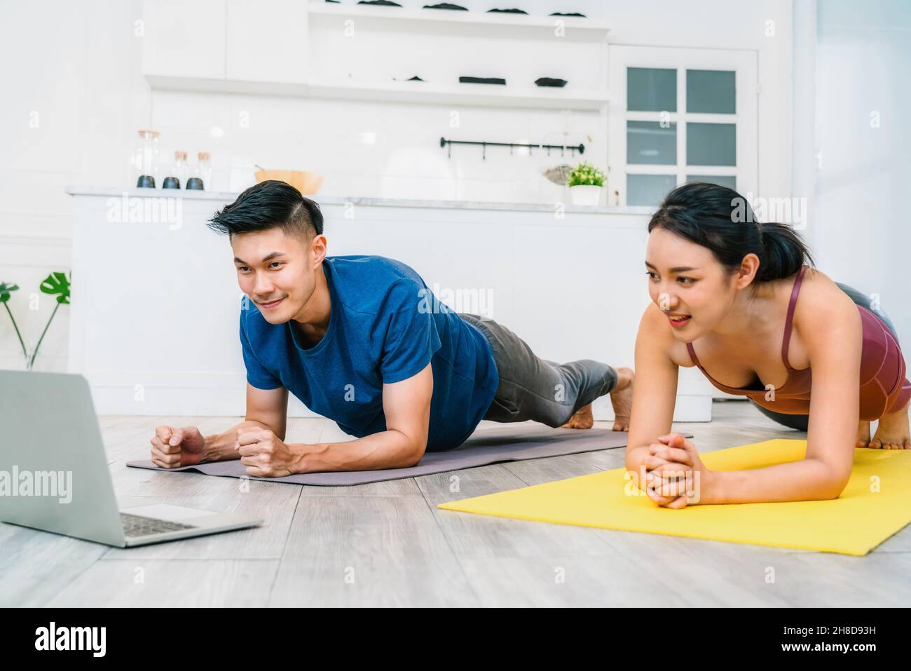 Exercises at home concept, Two Asian couple practicing yoga at home ...