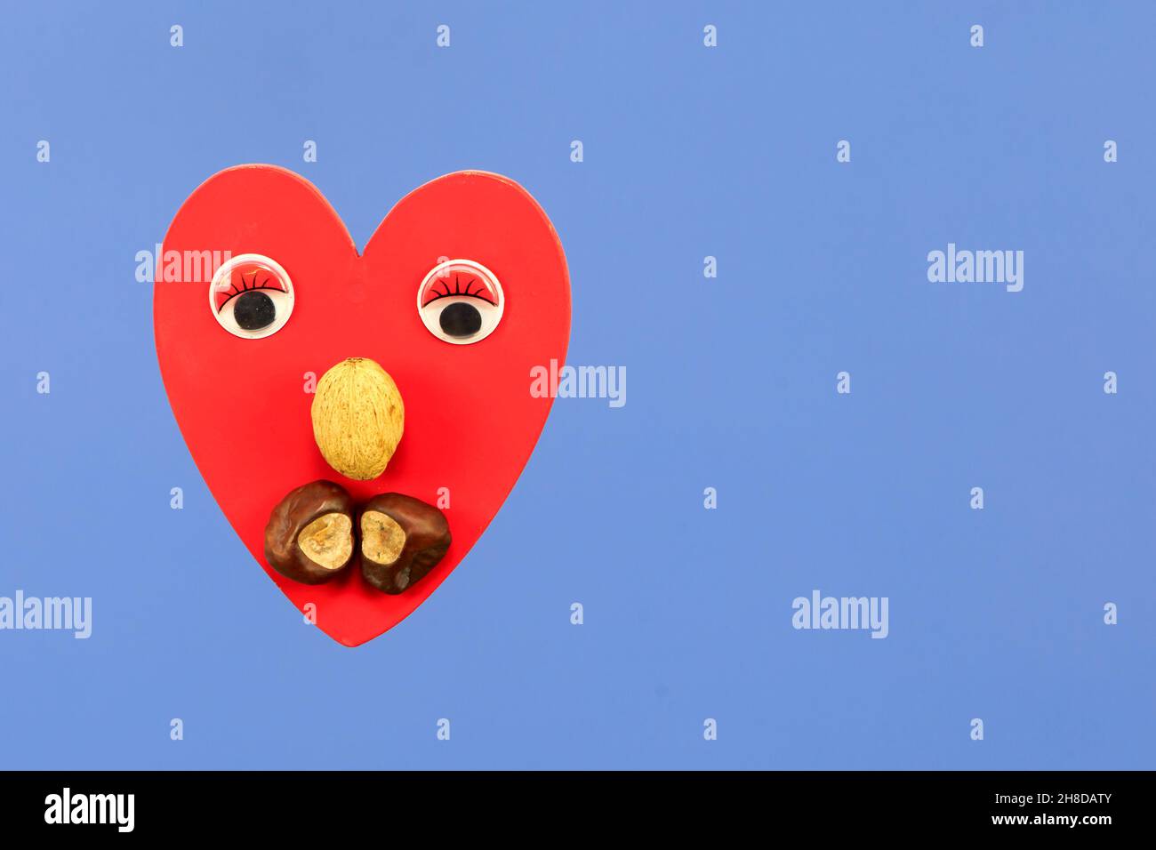 Red Comical Heart Face against a blue background Stock Photo - Alamy