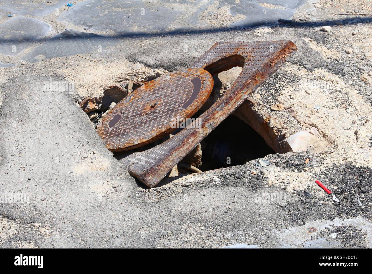 Dangerous city sidewalk in Bari, Italy. Hazardous damaged manhole cover ...