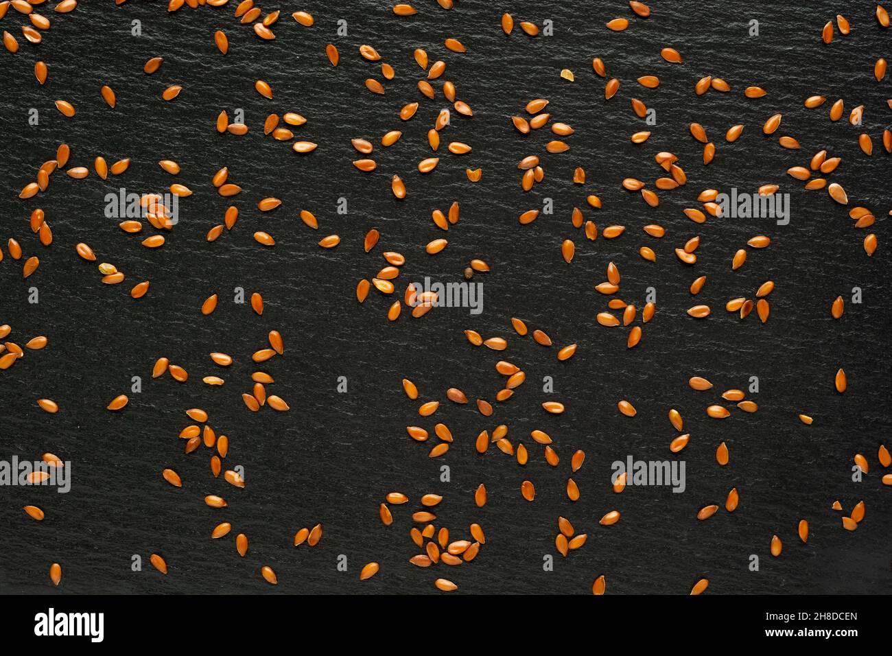 Organic Flax seeds on black slate stone background Stock Photo - Alamy