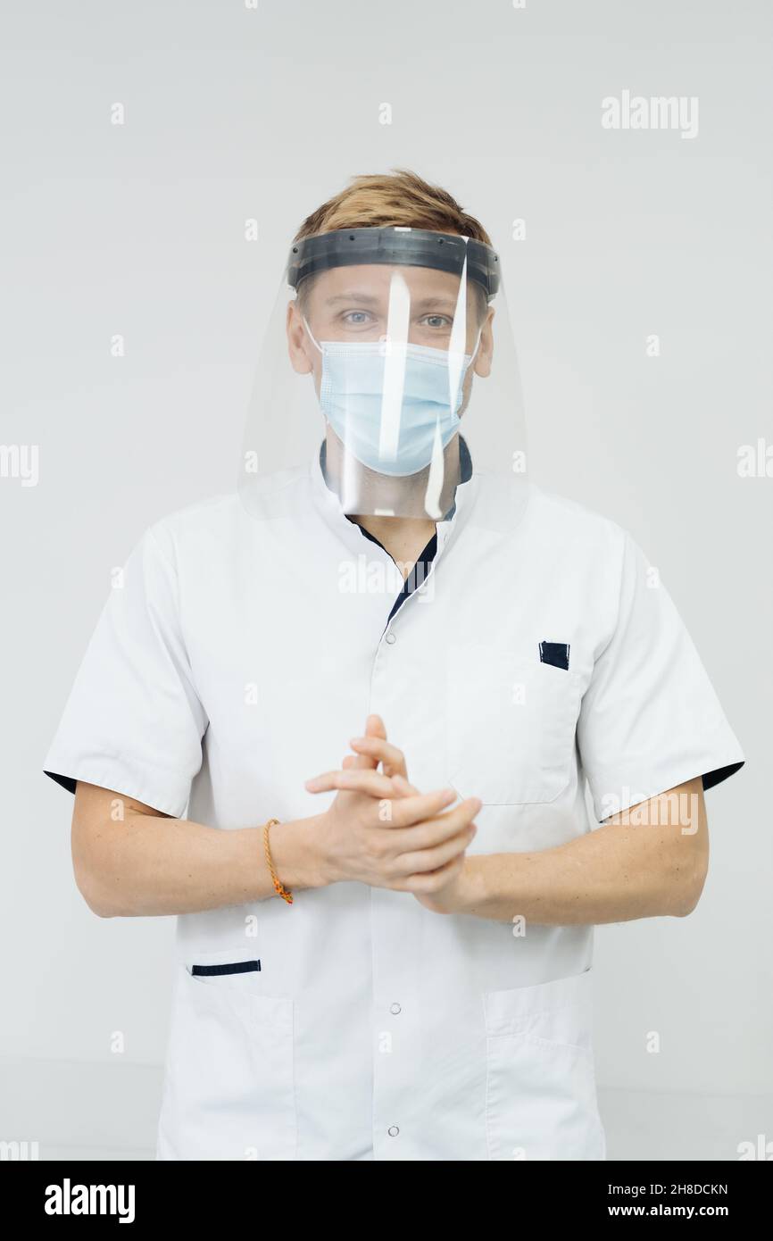 Portrait of a young male medical doctor wearing sterile mask and ...