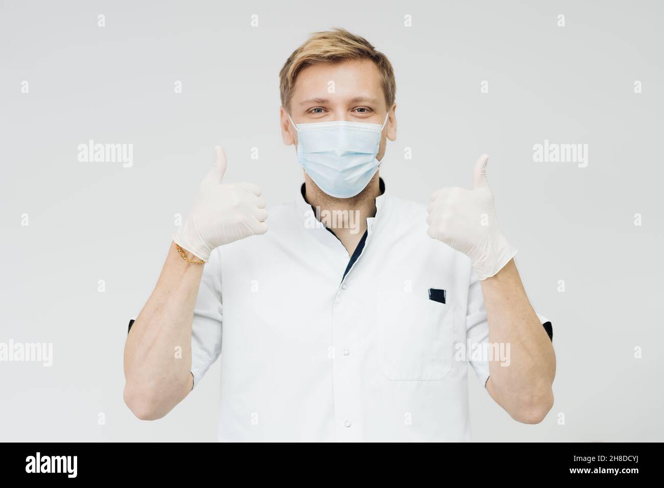 Attractive male doctor show thumbs up hand sign isolated on white ...