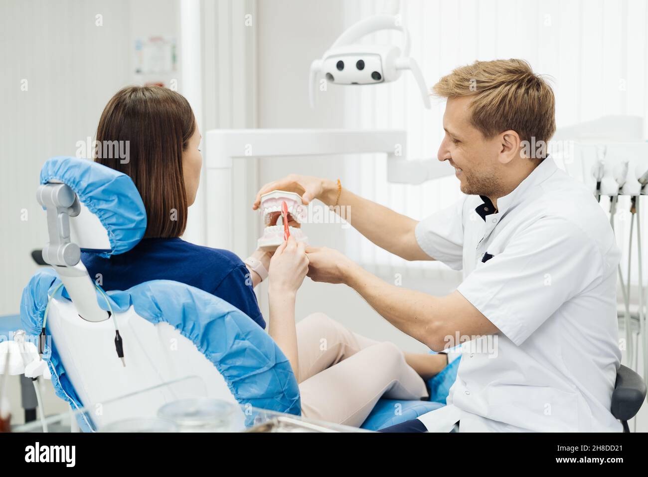 Dentist showing the correct dental hygiene using mock-up of skeleton of ...