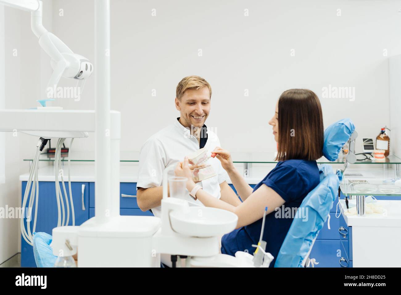 Dentist showing the correct dental hygiene using mock-up of skeleton of ...