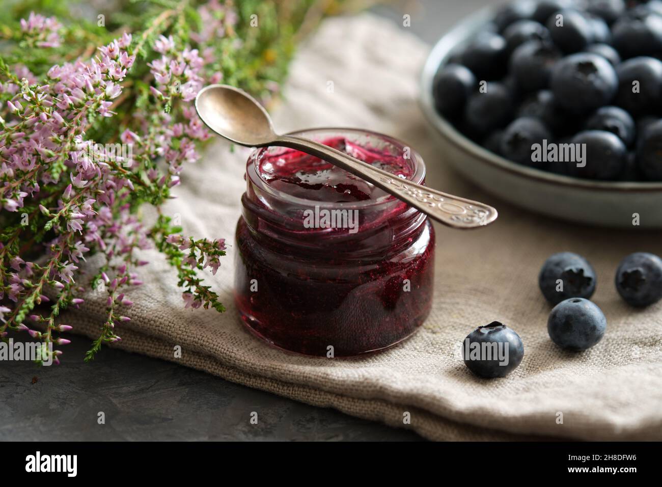 Small jar of blueberry jam and plate of fresh ripe blueberries on ...