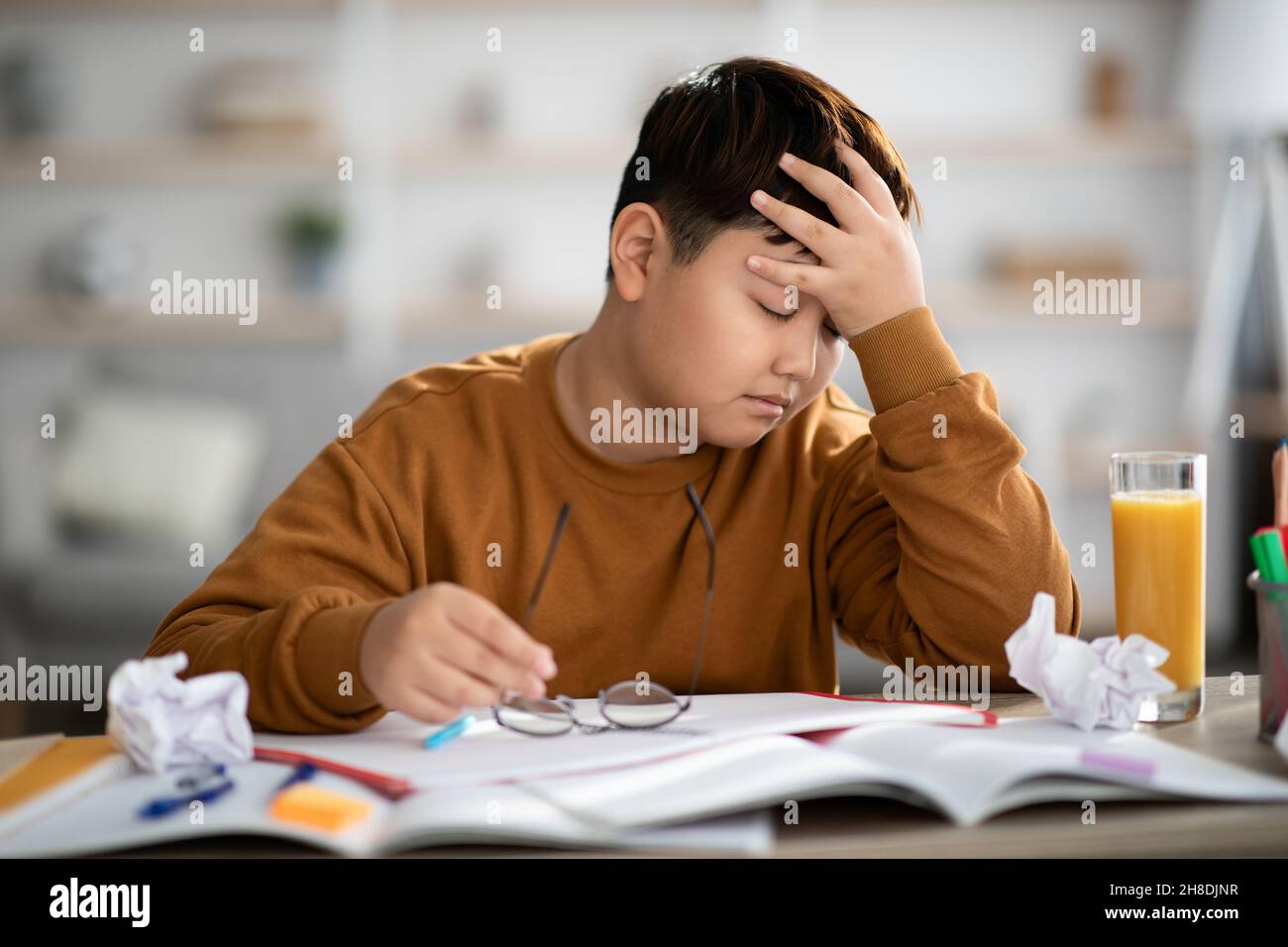 Exhautsed asian kid doing homework, experiencing difficulties, copy ...