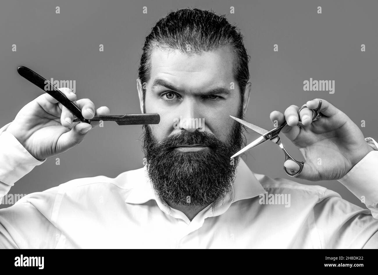 Brutal guy, scissors, straight razor. Bearded client visiting barber ... Brutal guy, scissors, straight razor. Bearded client visiting barber ...