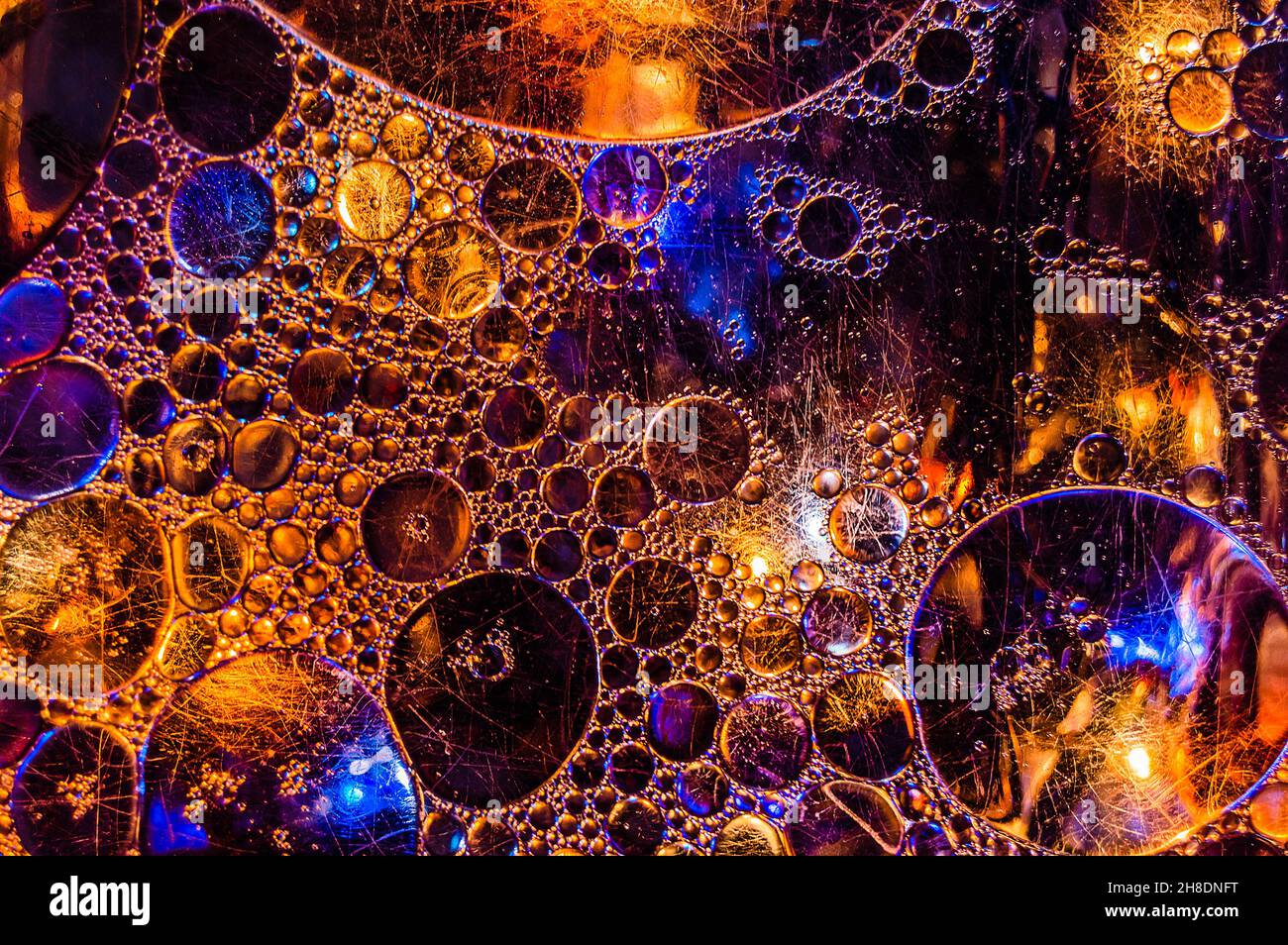 Textured background of oil drops in a glass of water in different ...