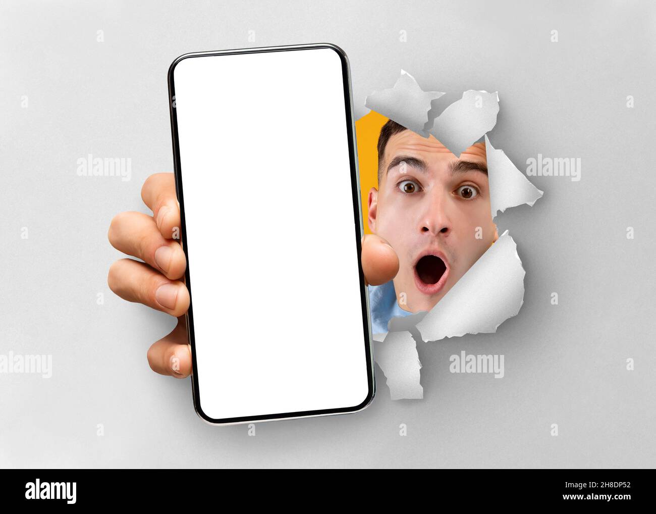 Shocked man showing white empty smartphone screen breaking through ...