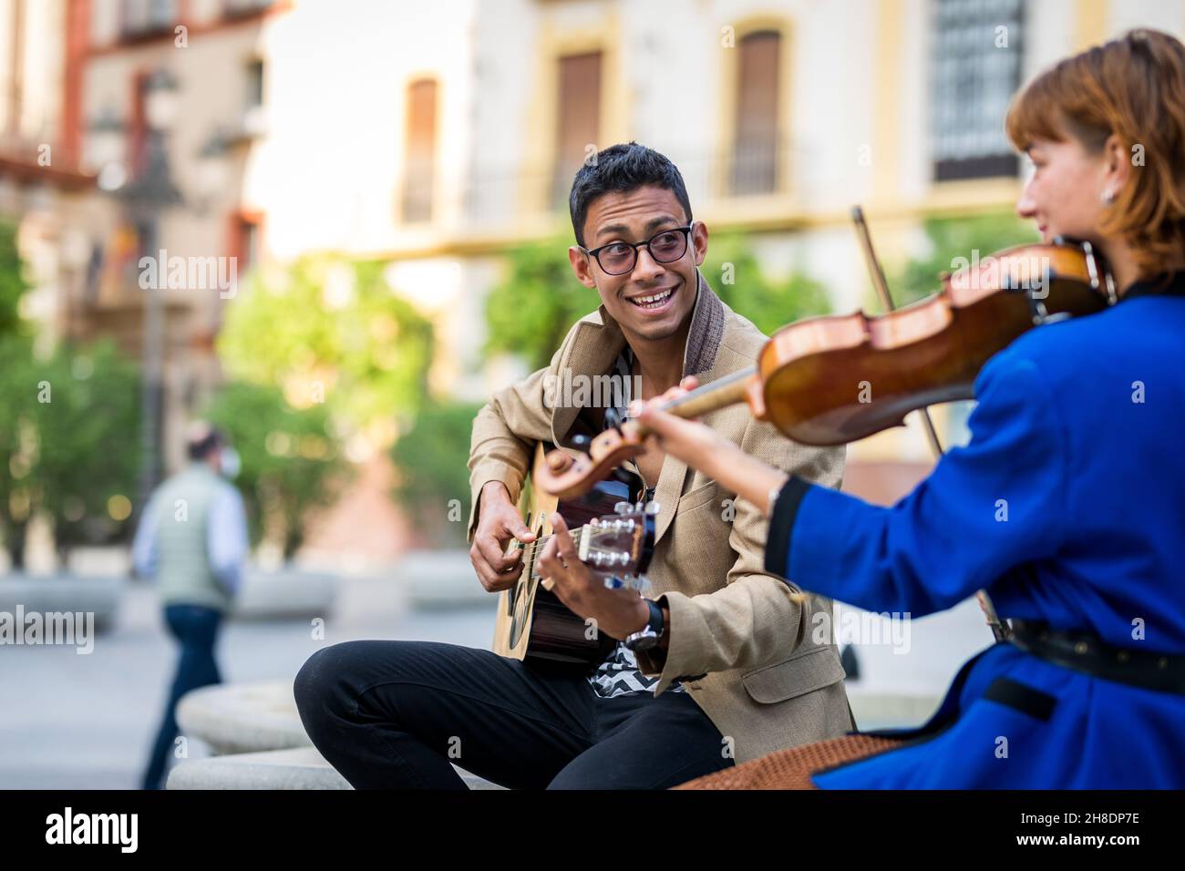 Musicians couple playing and having fun on the street. Latin guitarist ...