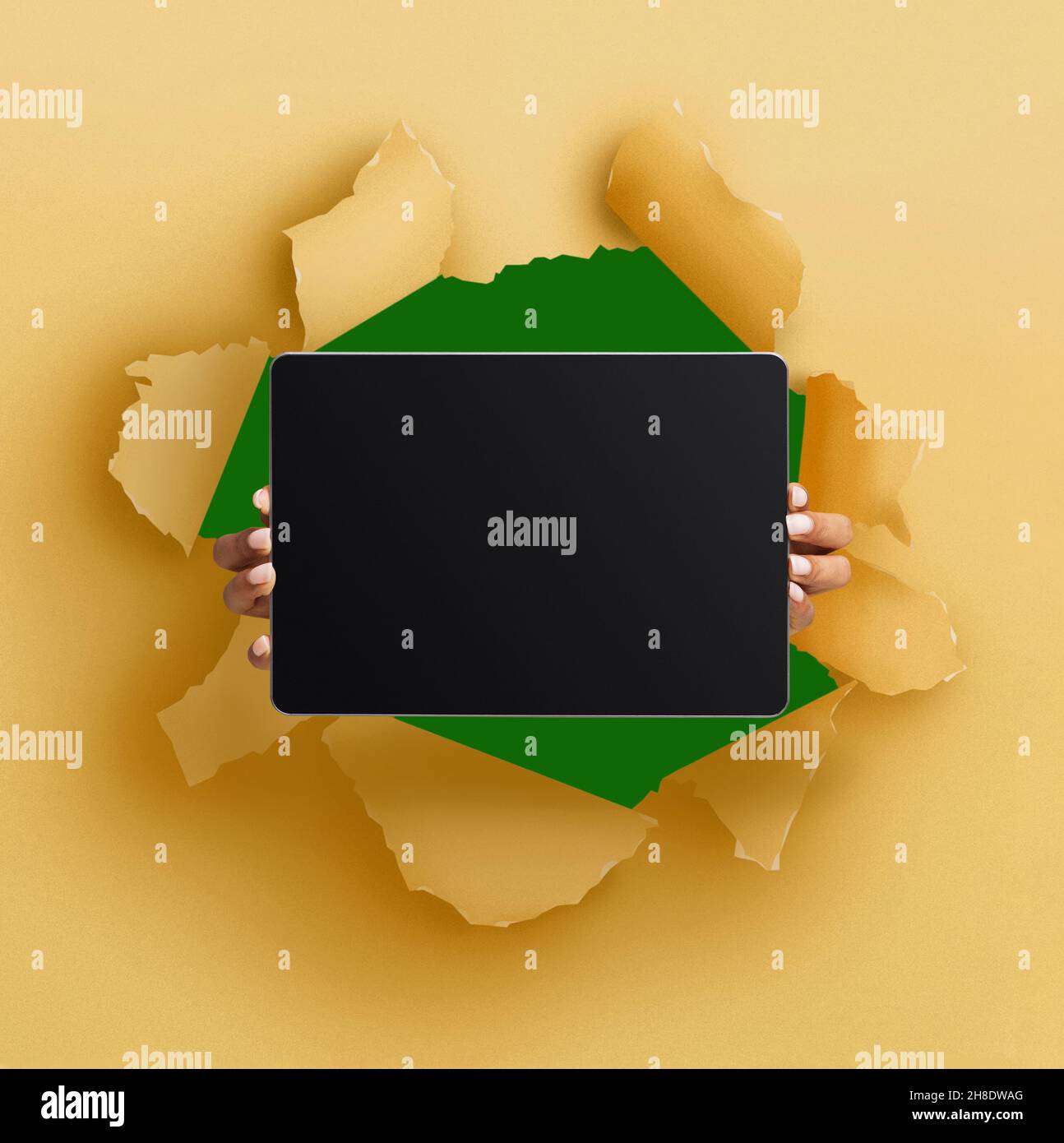 Black woman showing black empty tablet screen breaking through paper ...
