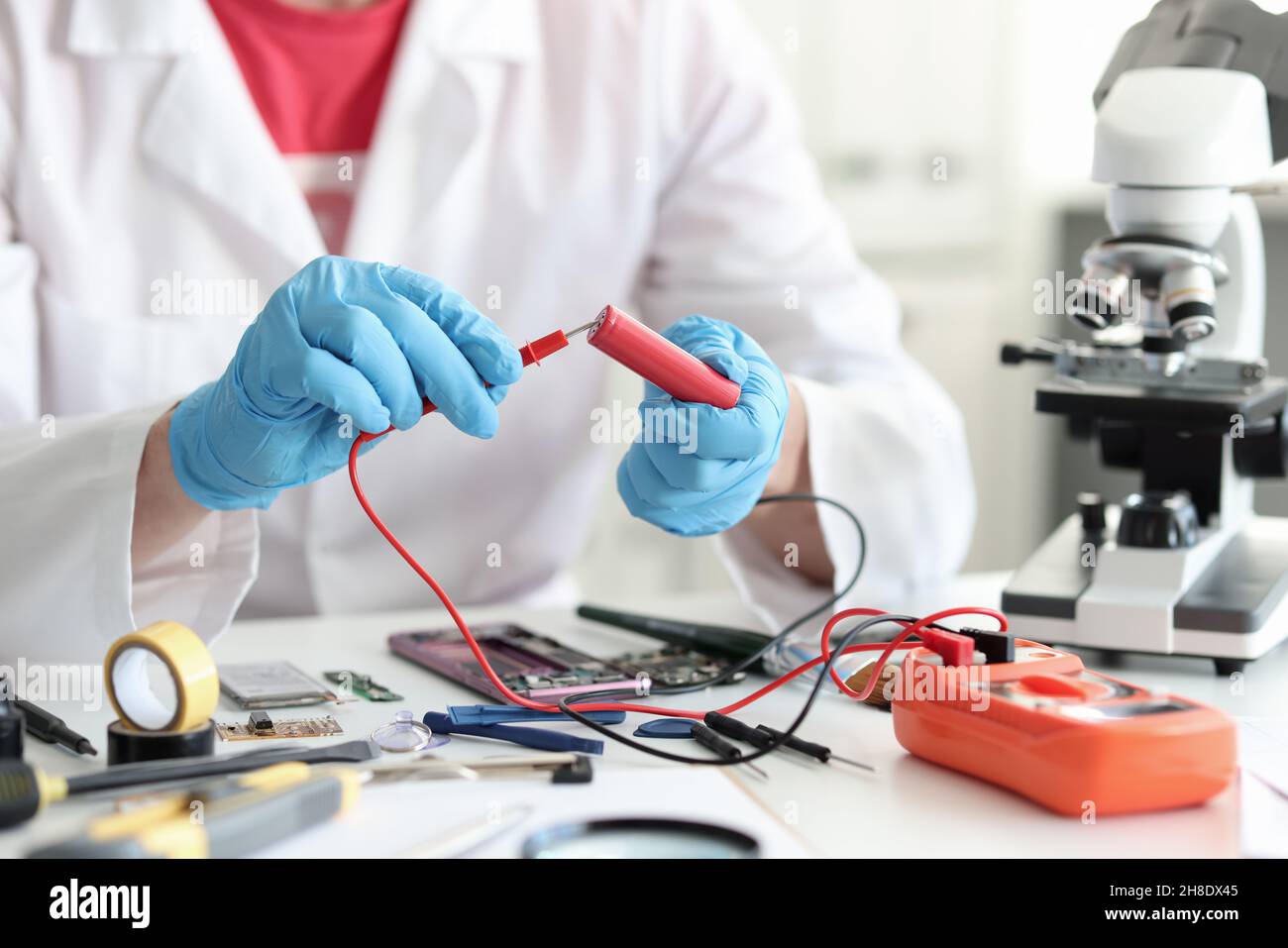 Master repairman checking battery charge using tester closeup Stock ...
