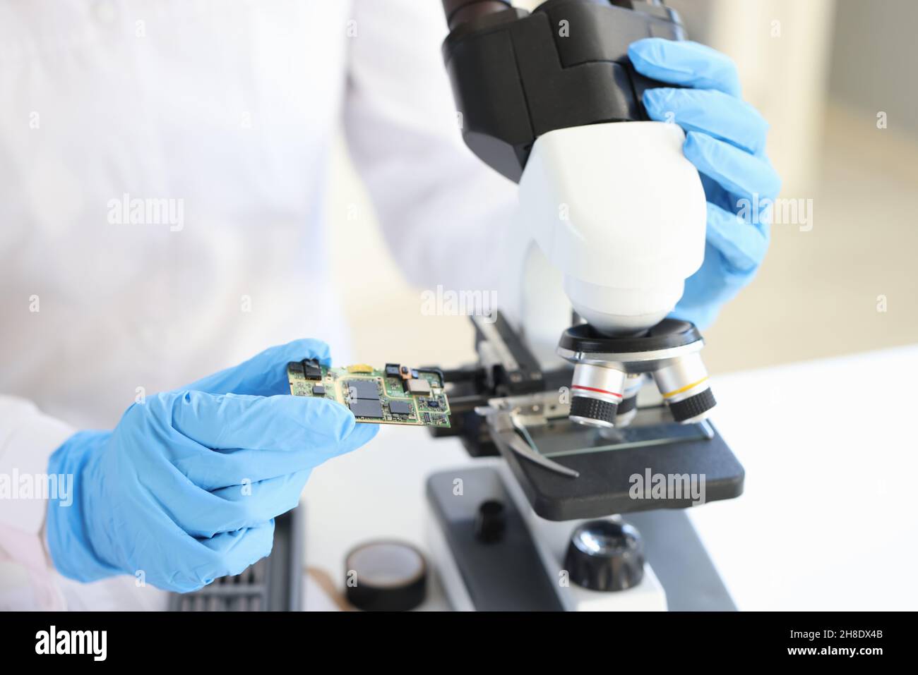 Scientist looking under microscope computer processor closeup Stock ...