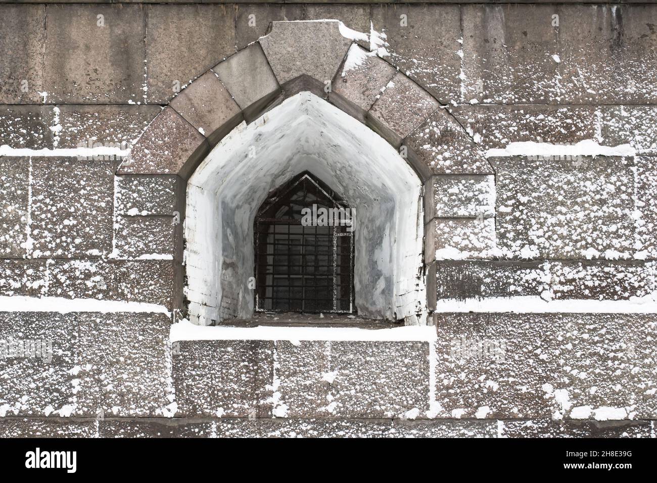 Ancient window in the thick wall of the fortress in winter in the snow ...