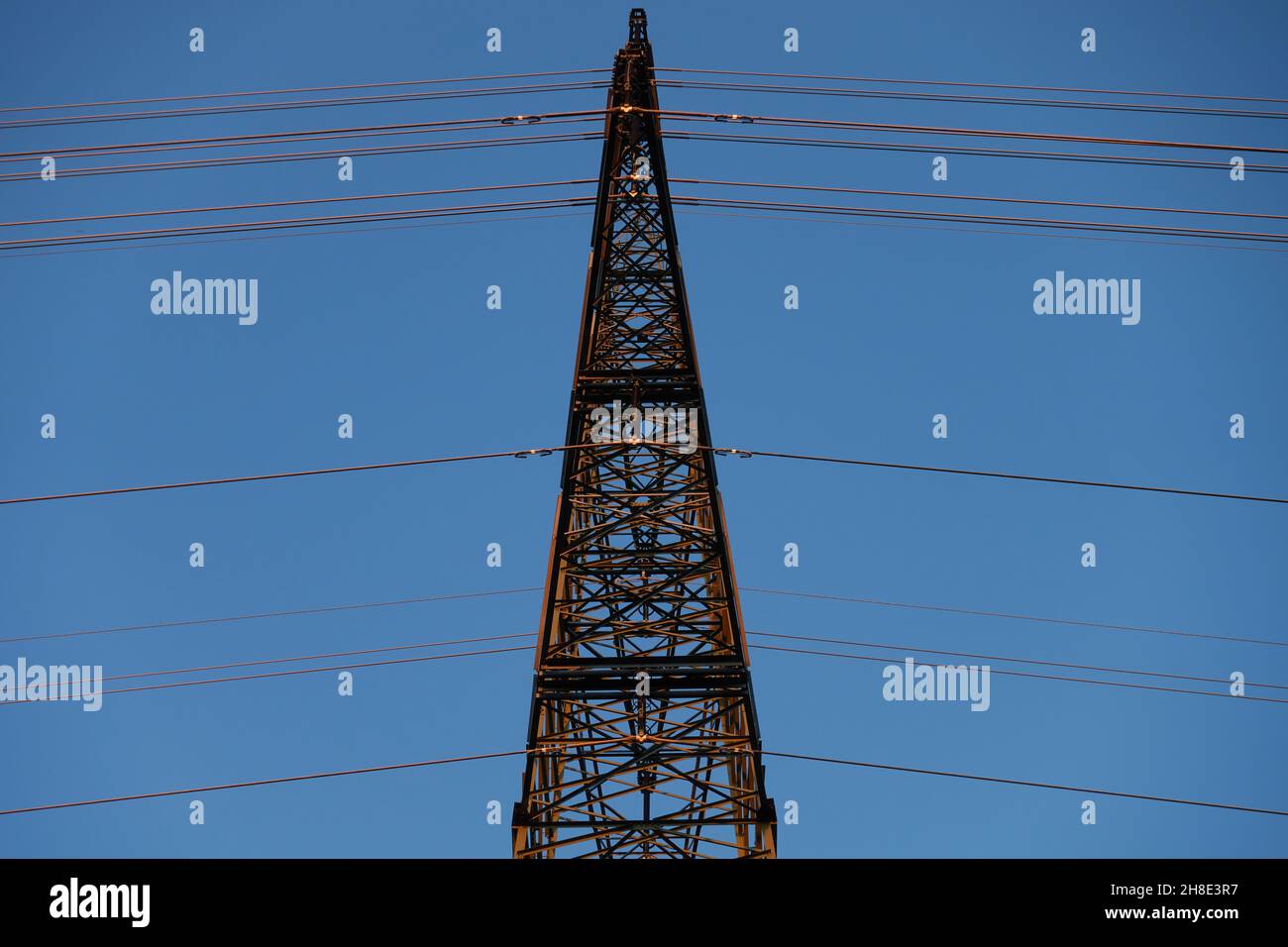 Large electricity pylon also overhead line pylon. Dark blue evening sky ...