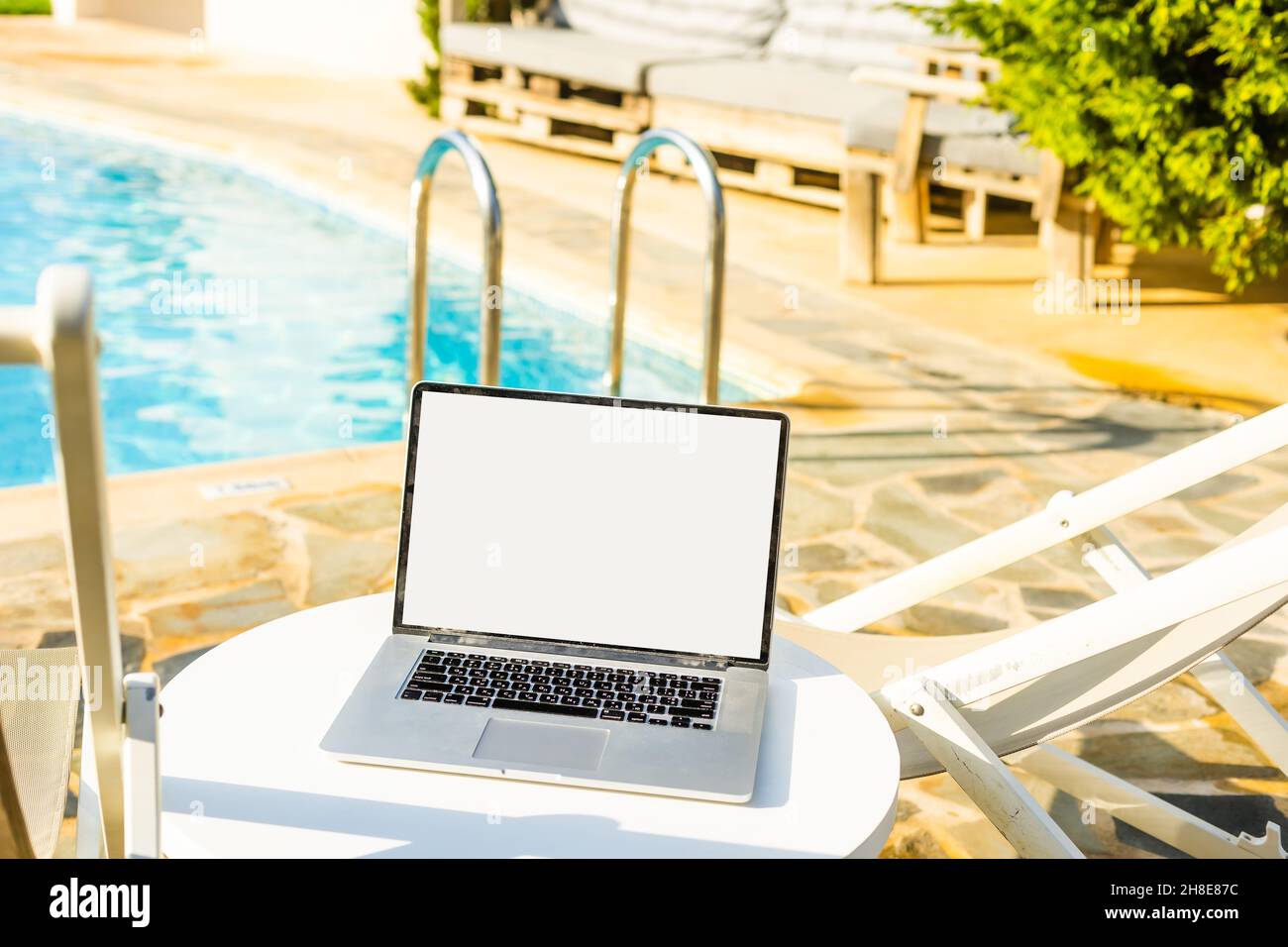 laptop computer on table pool background Stock Photo - Alamy