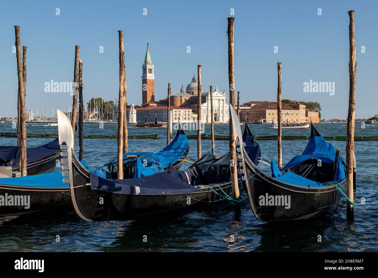 the typical Venetian view with gondolas, a typical Venetian boat and in ...