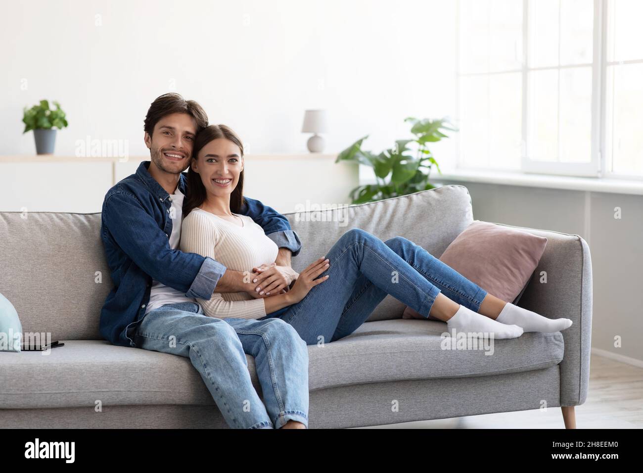 Smiling happy young caucasian husband hugging wife, enjoying tender ...