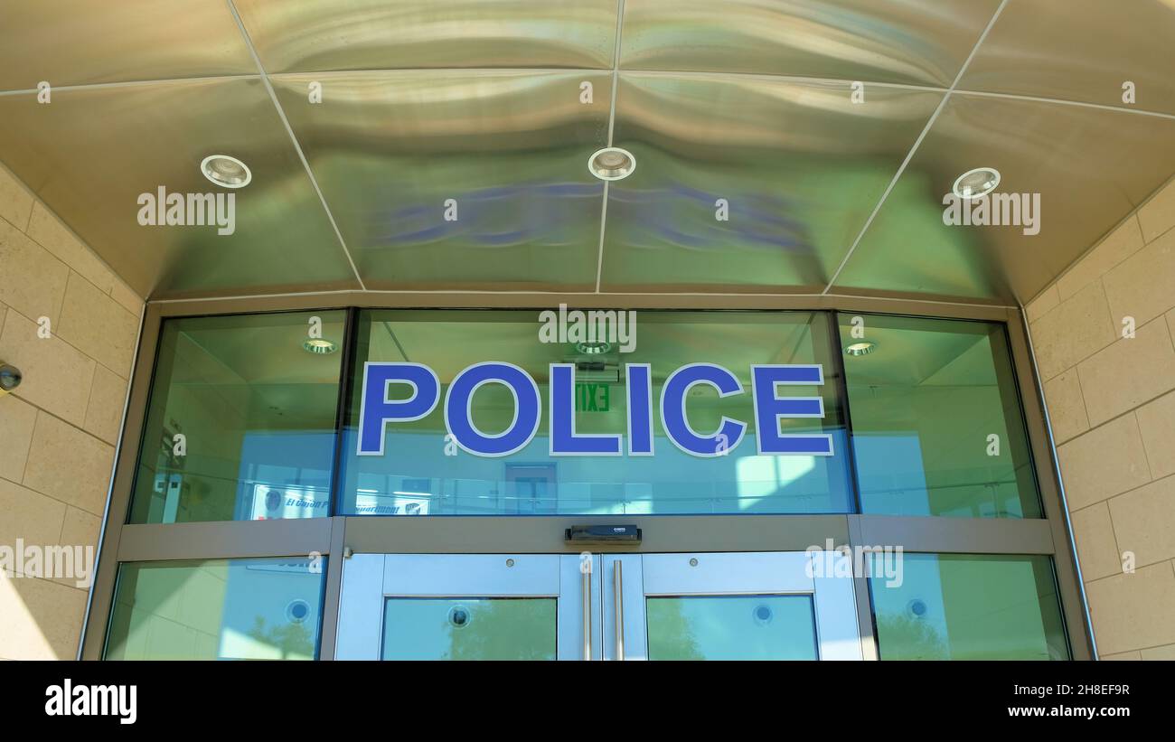 The word POLICE in blue capital letters on a glass pane above the main ...