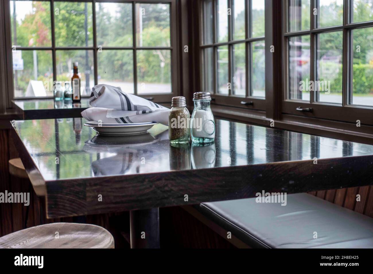Angled view of a wooden table inside a restaurant, topped with clean ...