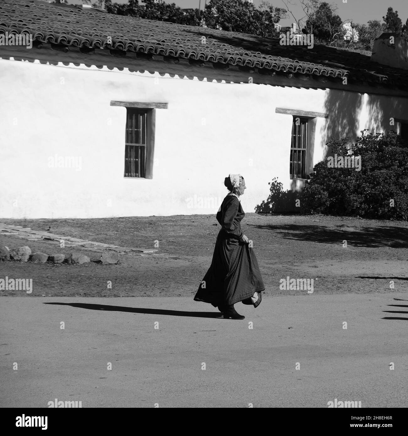 A woman in a pioneer period dress walking in Old Town, San Diego ...