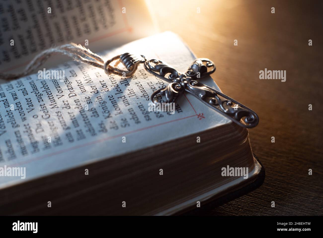 Closeup of beautiful Christian cross on a pray book on the old table ...