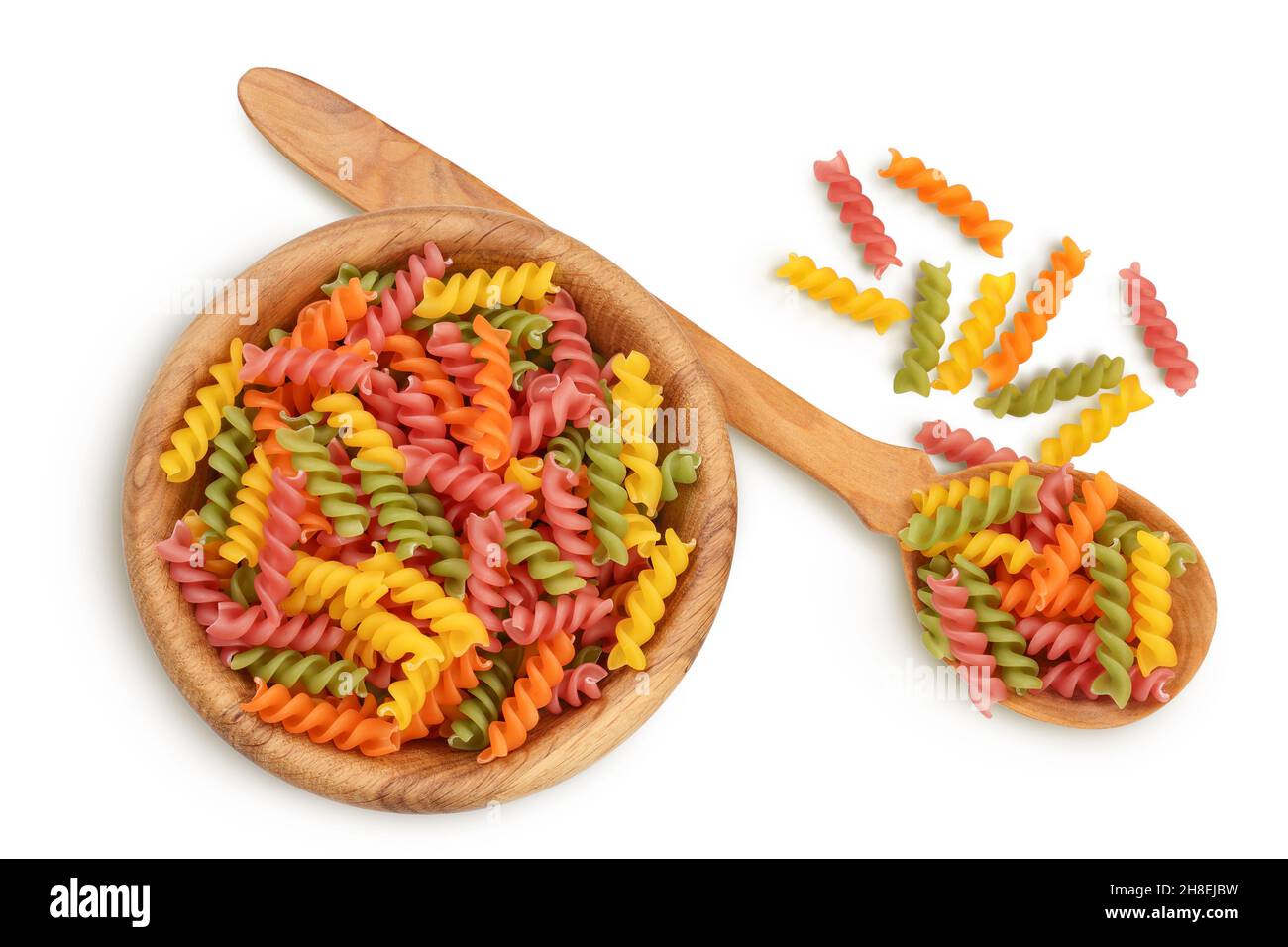 raw Fusilli colored pasta in wooden bowl isolated on white background ...