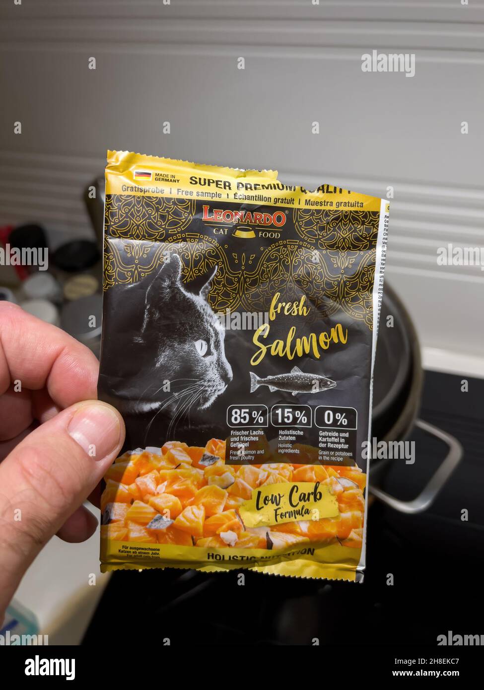 Male hand holding sample cat food manufactured by Leonardo Stock Photo ...