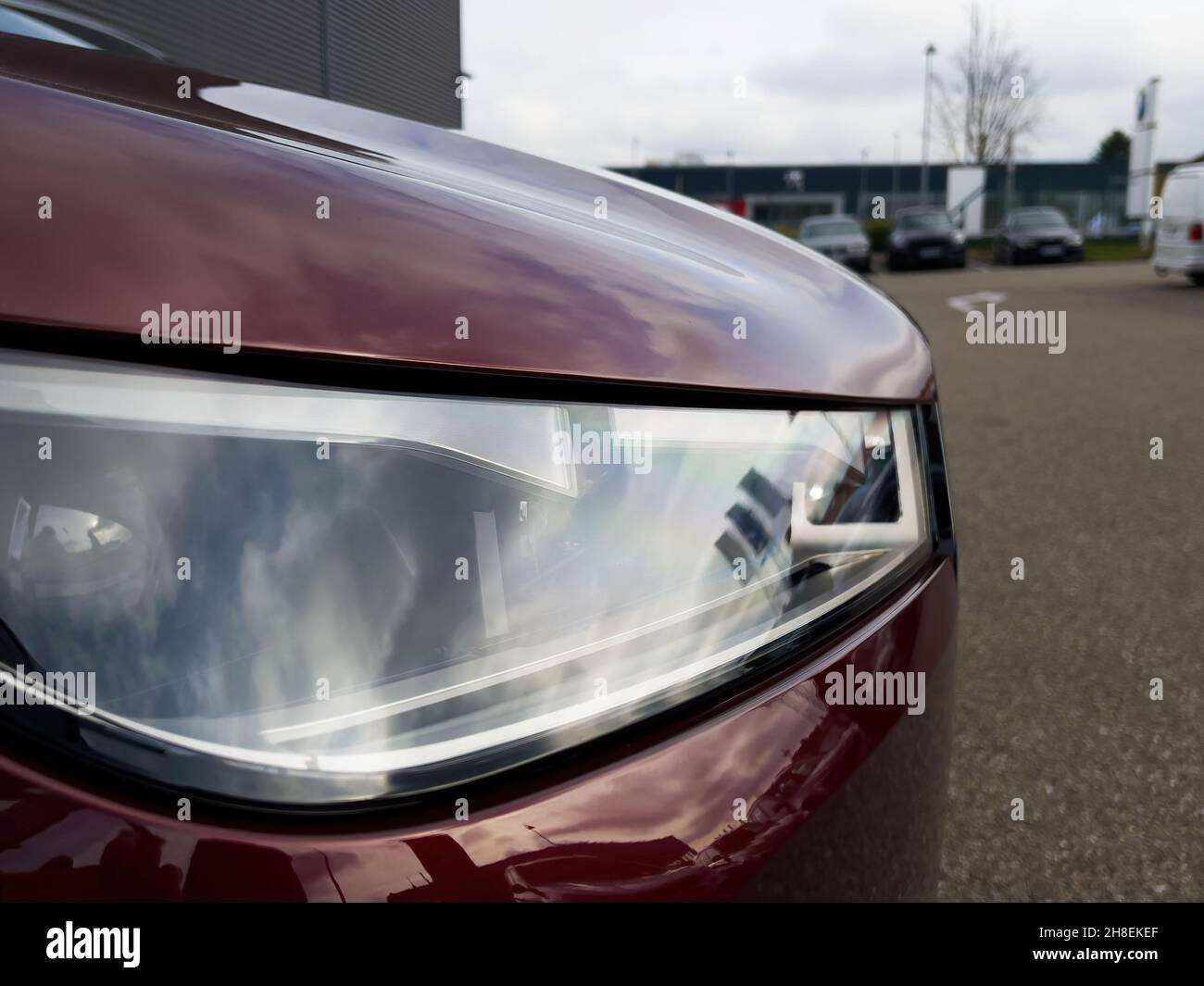 New xenon led laser light of a red luxury car in large car parking ...