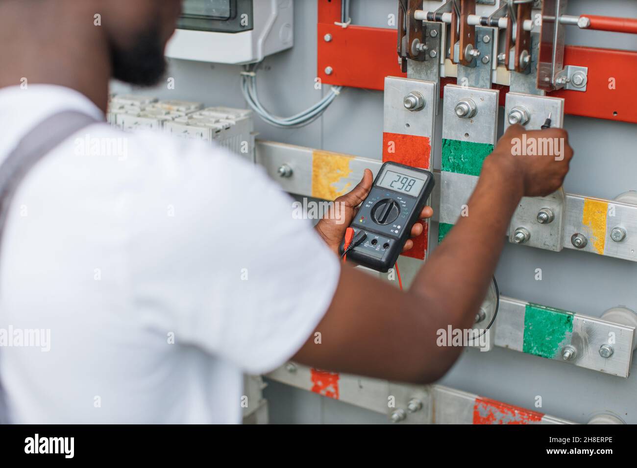 Close up of african american man standing near switchgear compartment ...
