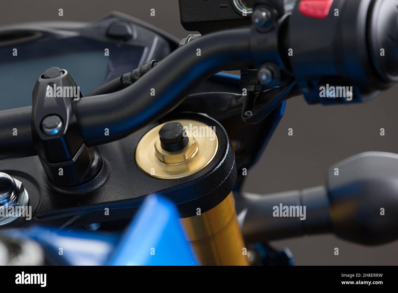 Closeup of the handlebars of a modern motorcycle outdoors with a blurry ...