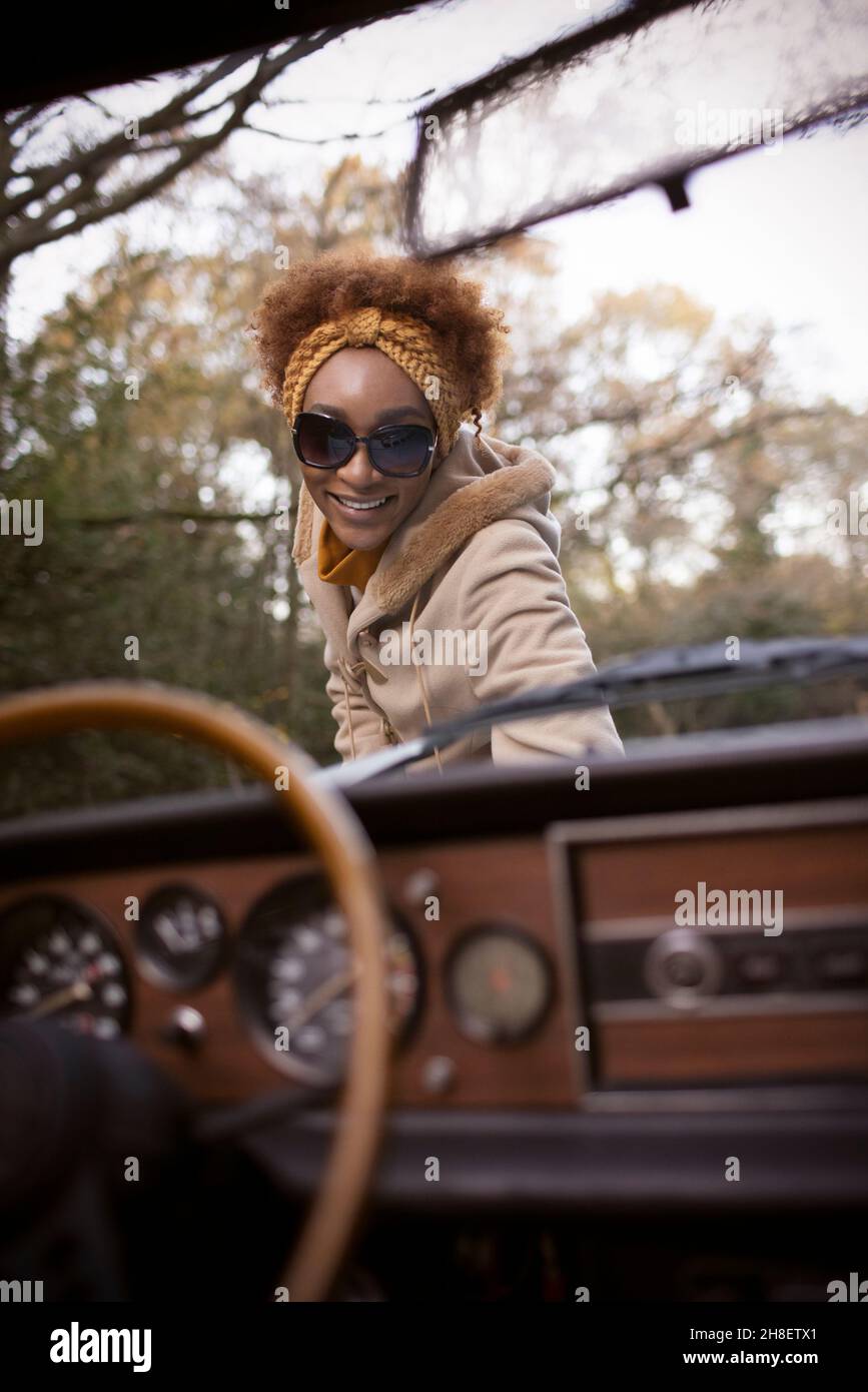 Portrait happy young woman outside convertible in park Stock Photo - Alamy