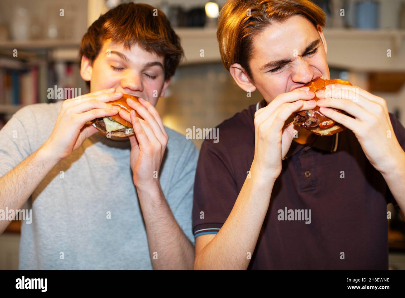 Hungry teenage boys eating hamburgers Stock Photo - Alamy