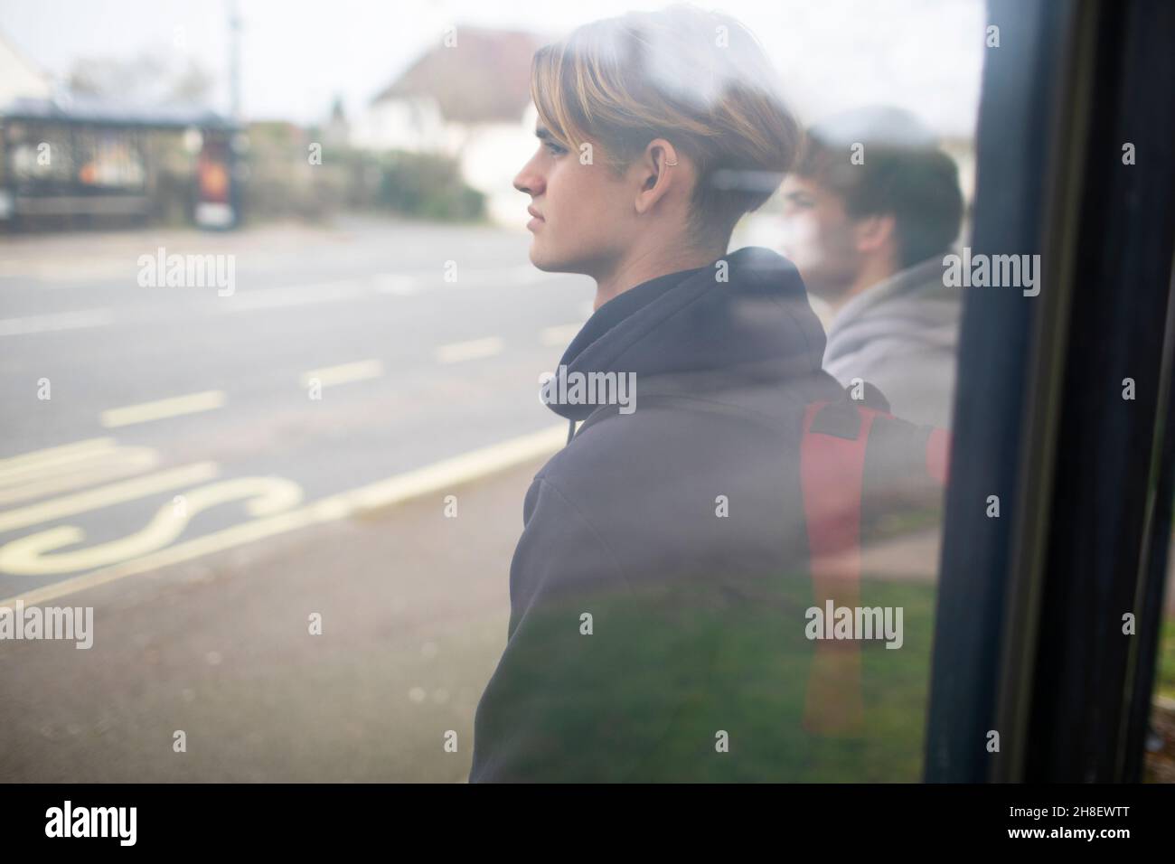 Teenage boys waiting at bus stop Stock Photo - Alamy