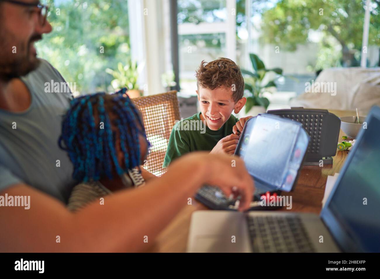 Happy boy at table with father and sister Stock Photo - Alamy