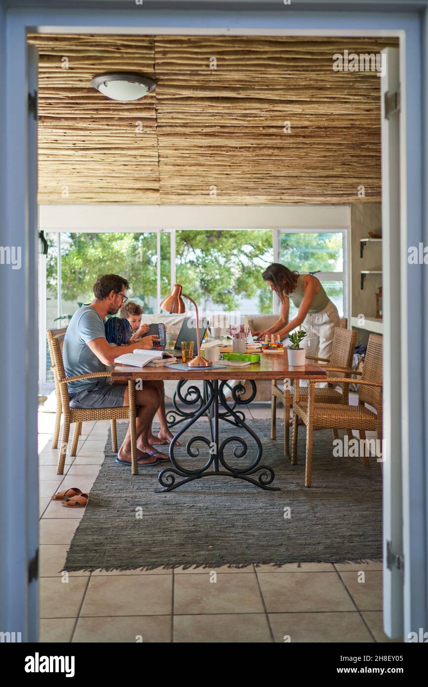 Family working and playing at dining table Stock Photo - Alamy