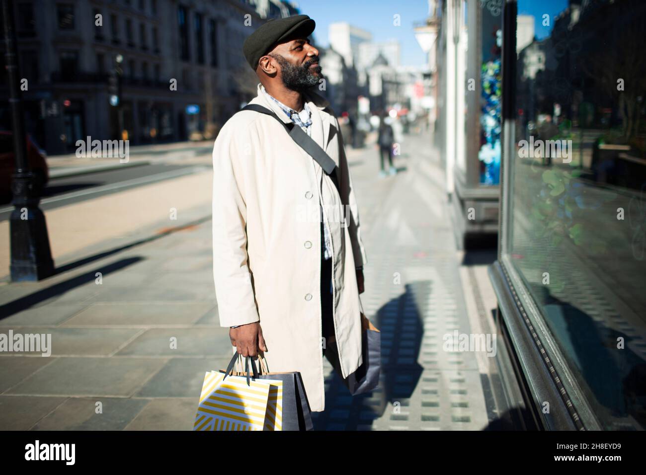 Man window shopping at sunny city storefront Stock Photo - Alamy
