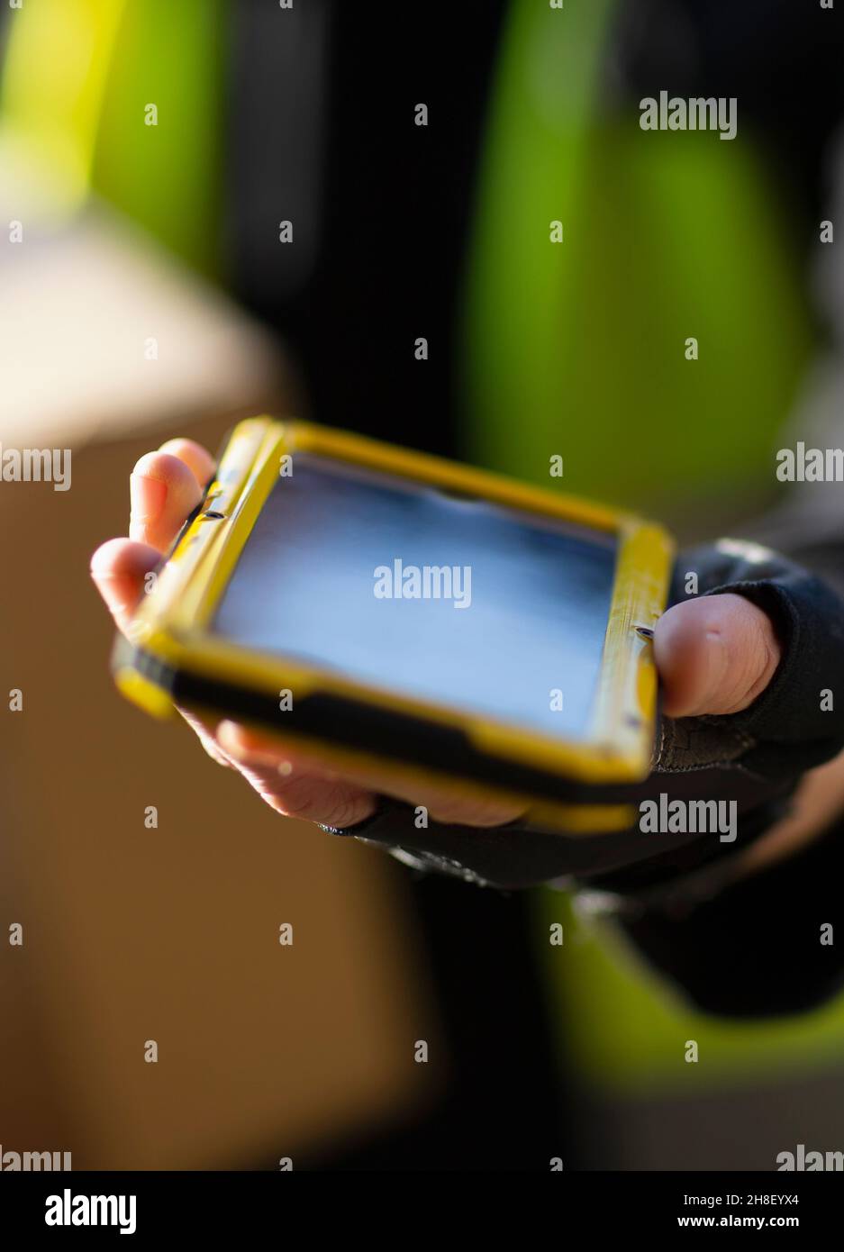 Close up courier with smart phone requesting signature for delivery ...