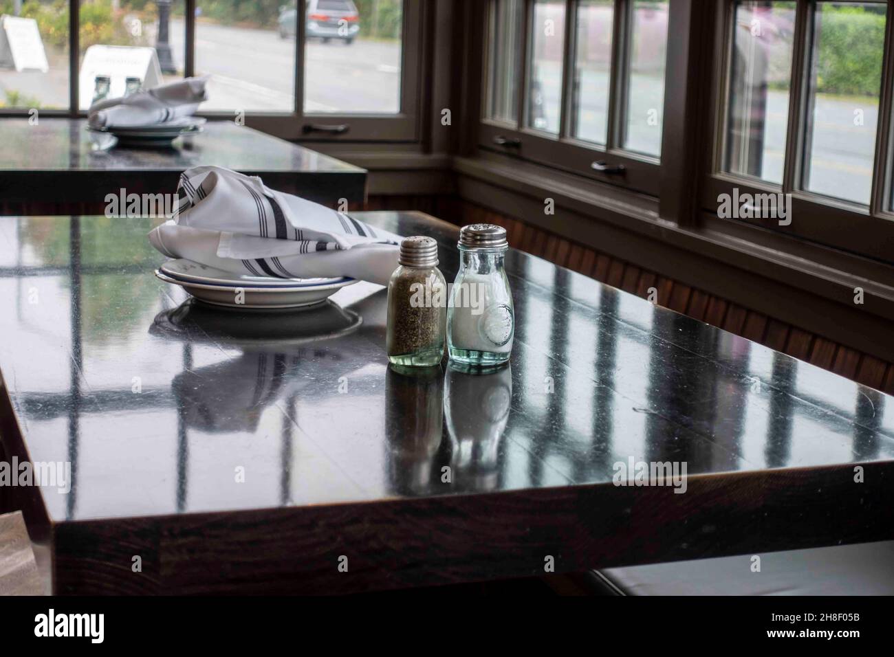 Angled view of a wooden table inside a restaurant, topped with clean ...