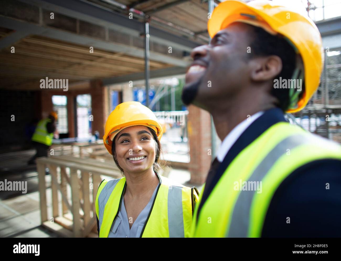 Happy construction workers talking at construction site Stock Photo - Alamy Happy construction workers talking at construction site Stock Photo - Alamy