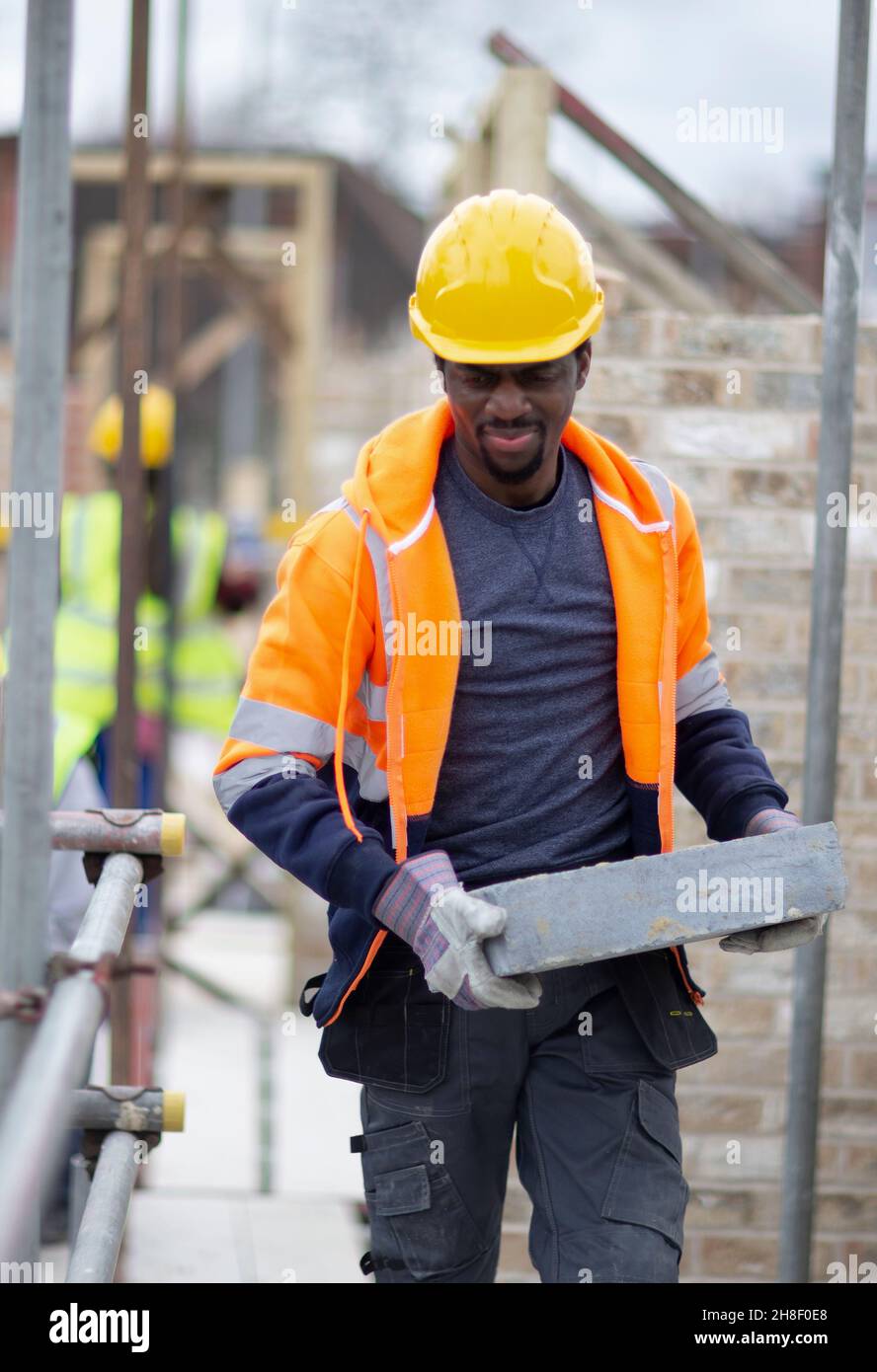 Male construction worker carrying brick at construction site Stock ...