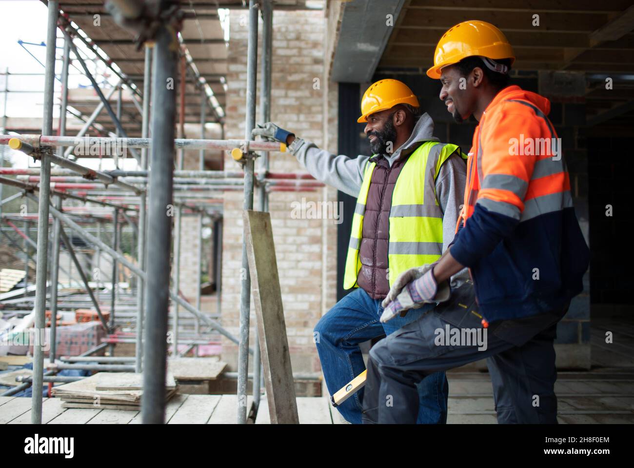 Male construction workers talking at construction site Stock Photo - Alamy