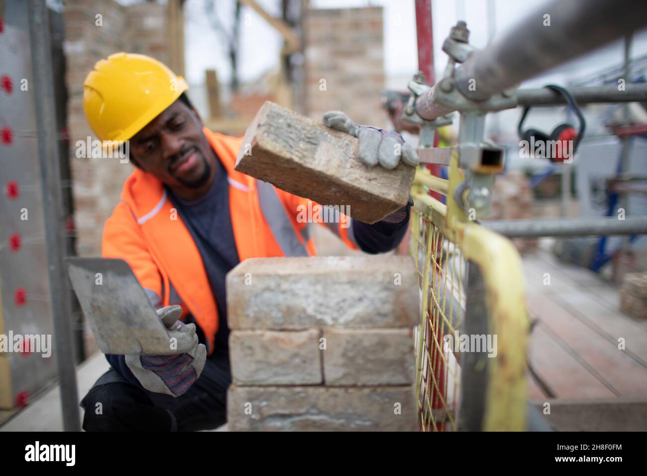 Male construction worker laying bricks at construction site Stock Photo ...