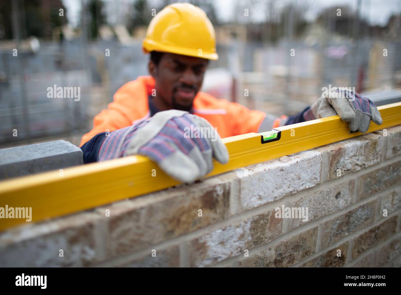 Male construction worker using level tool on brick wall Stock Photo - Alamy