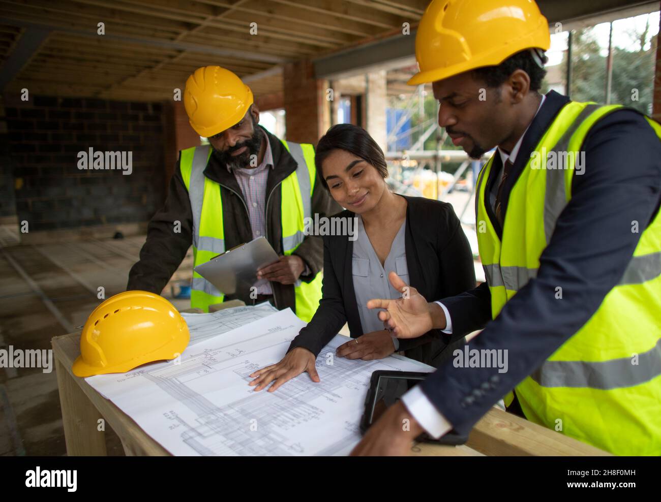 Architects and engineer discussing blueprints at construction site ...