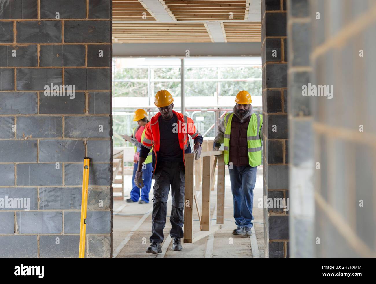 Construction workers carrying wood frame at construction site Stock ...