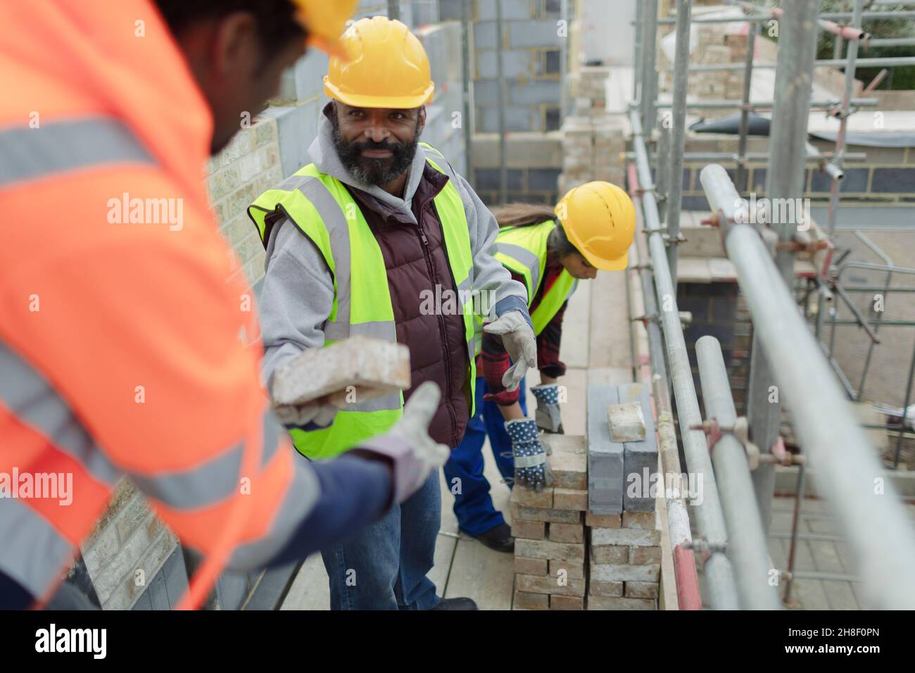 Construction workers laying brick at construction site Stock Photo - Alamy