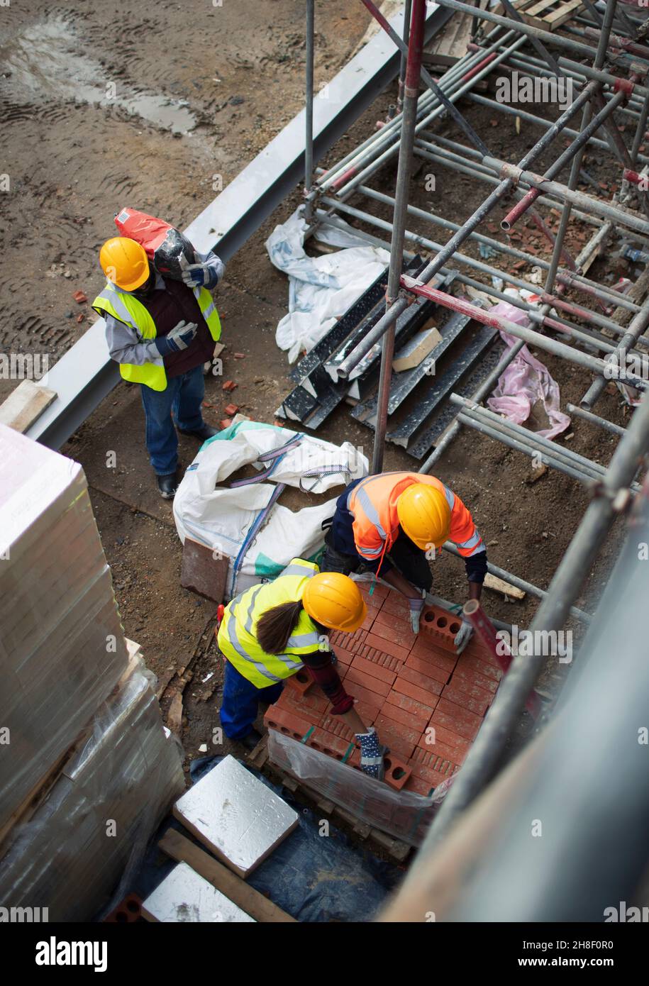 Construction workers with bricks at construction site Stock Photo - Alamy